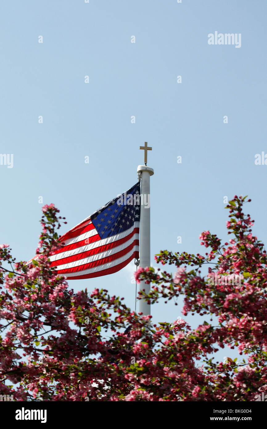The Catholic church with a cross and US flag on a flagpole with ...