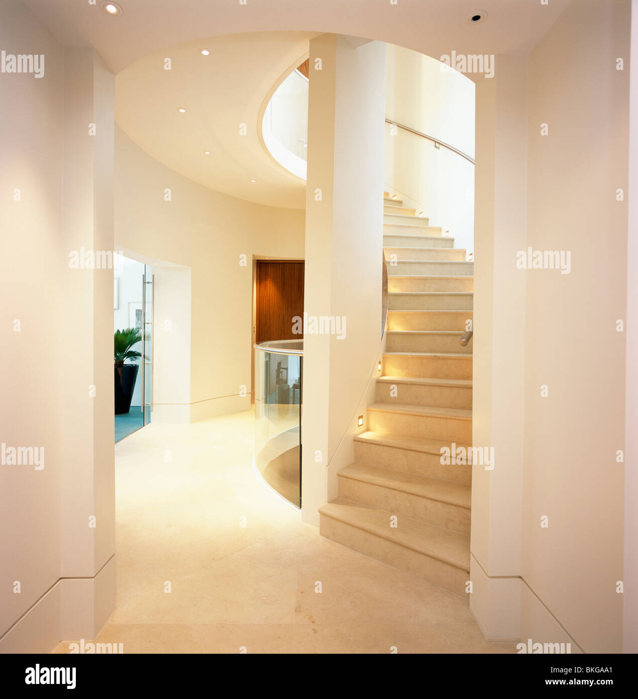 Curved staircase with under-lit treads in modern white hall Stock Photo ...