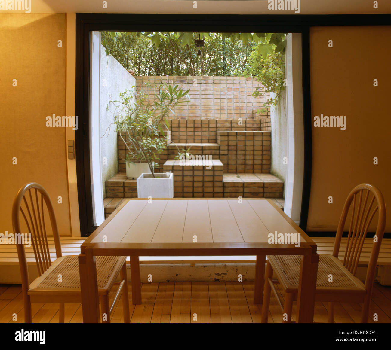 Modern dining room with pale wood table and chairs in front of large ...