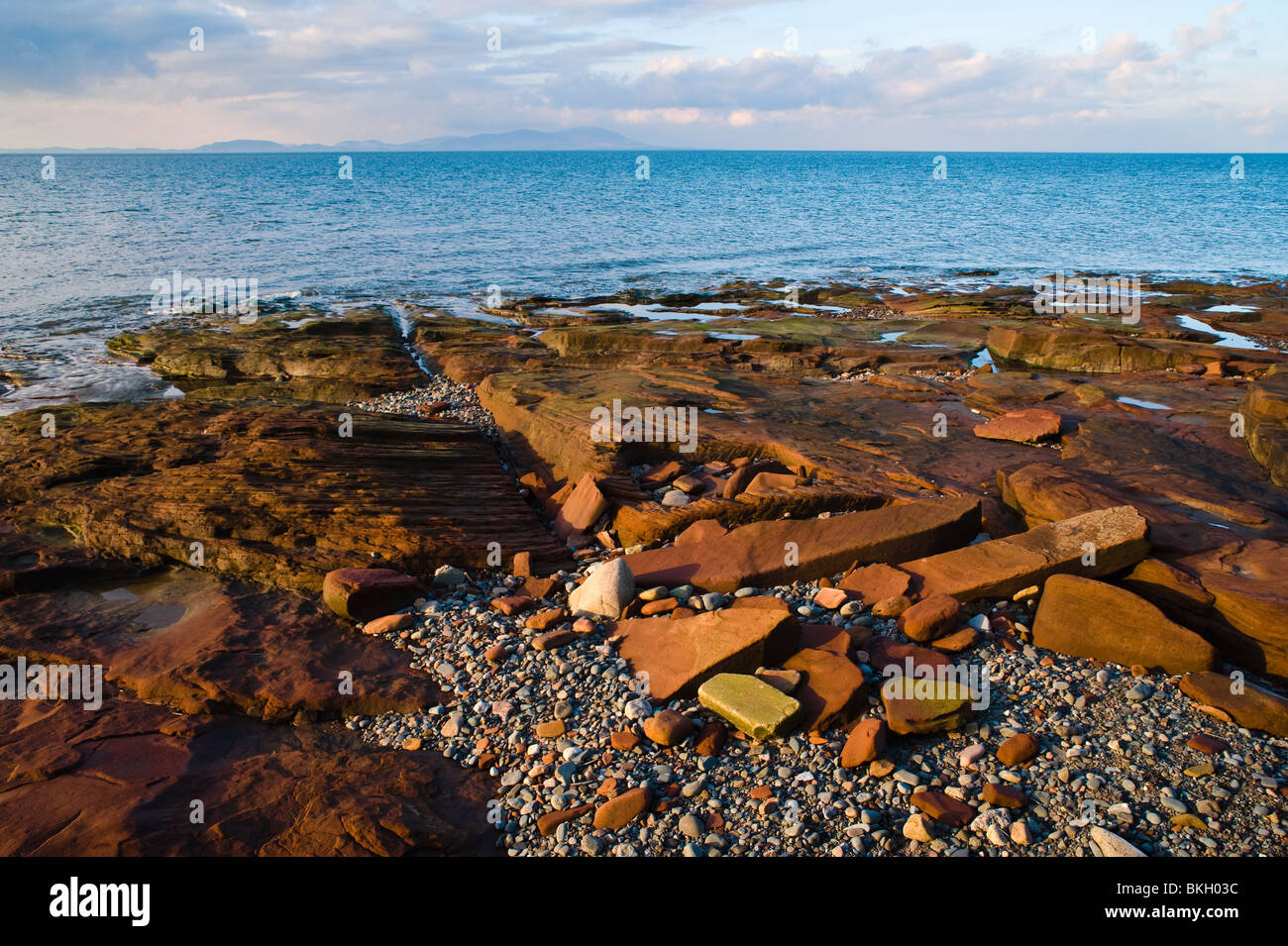 Rocky shoreline at Maryport, Cumbria, looking across the Solway Firth ...
