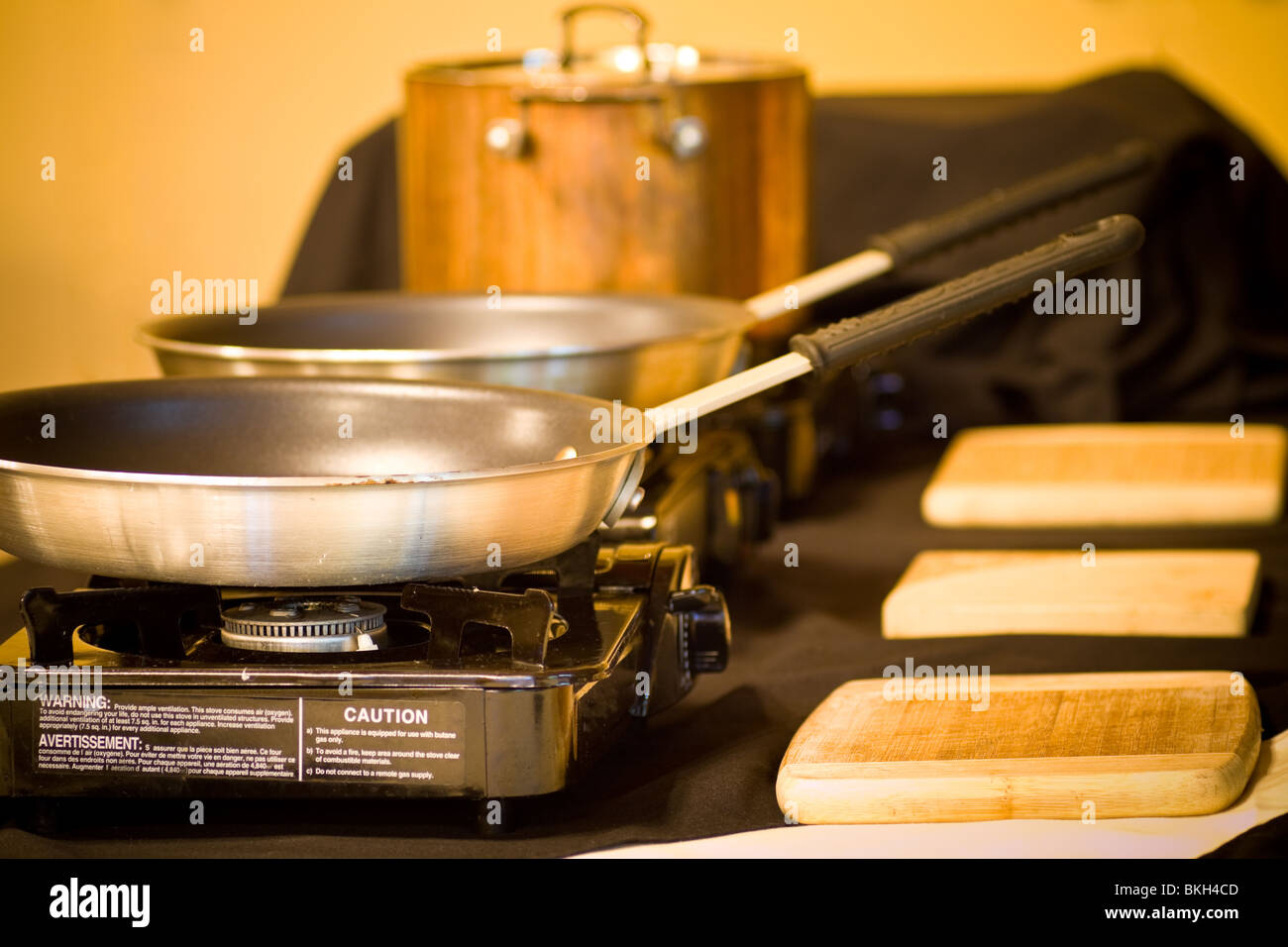 A couple of empty frying pans on a portable stove along a buffet line ...