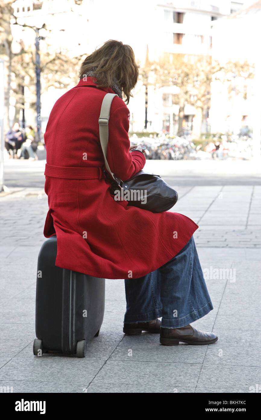 sitting on suitcase Stock Photo - Alamy