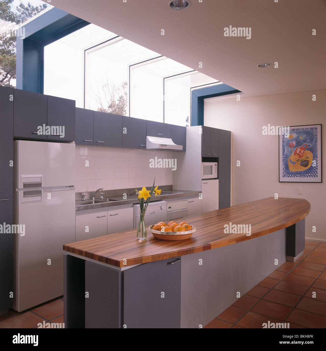 Wood worktop on long island unit in modern kitchen extension with glass ...