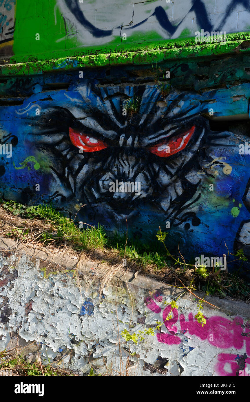 Evil troll with red eyes under a bridge graffiti on wall at Keele ...