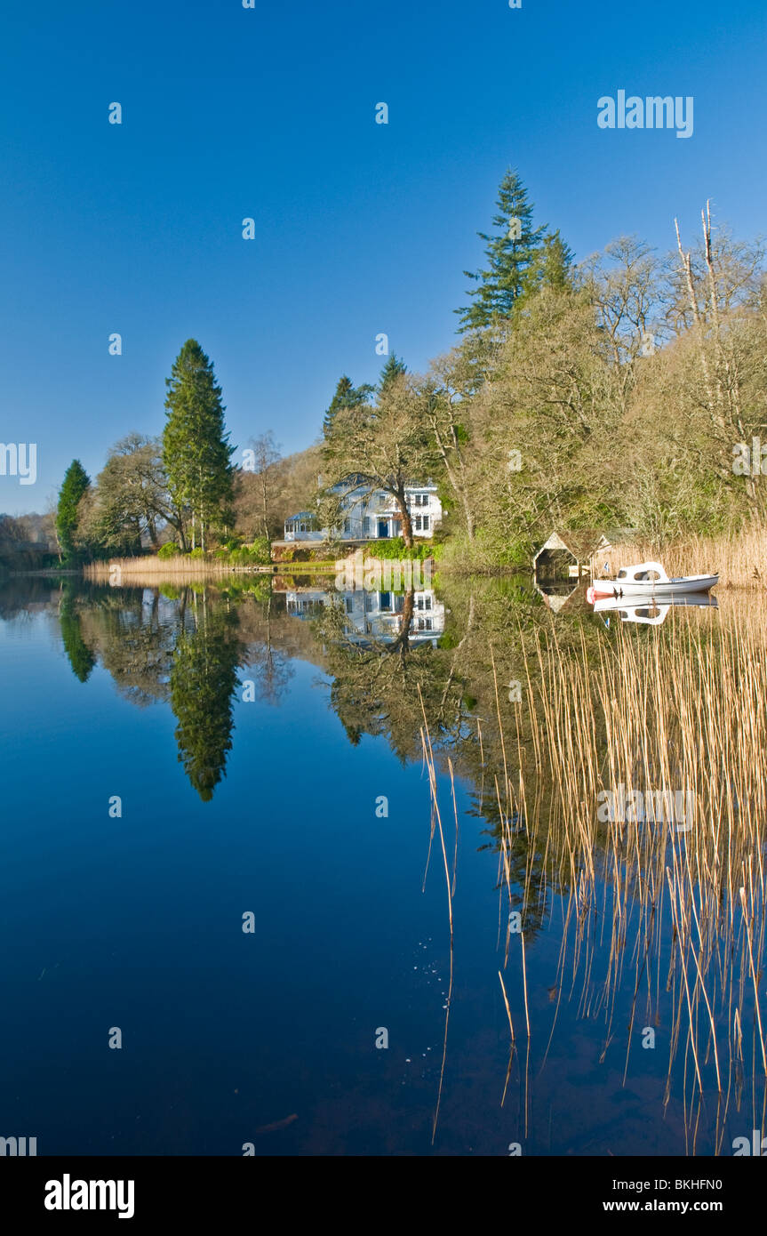 Boat reeds & house reflected on Loch Ard nr Aberfoyle Trossachs ...