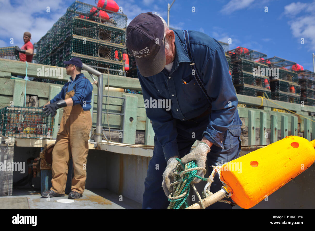 Fishermen loading lobster traps on lobster boat at Escuminac Wharf on ...