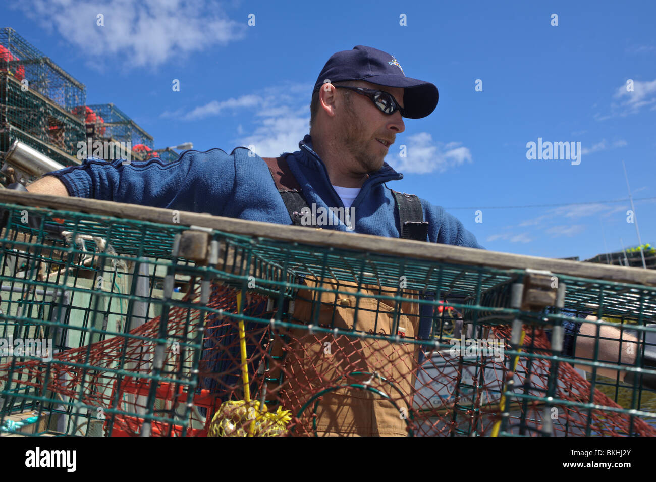 Fishermen loading lobster traps on lobster boat at Escuminac Wharf on ...