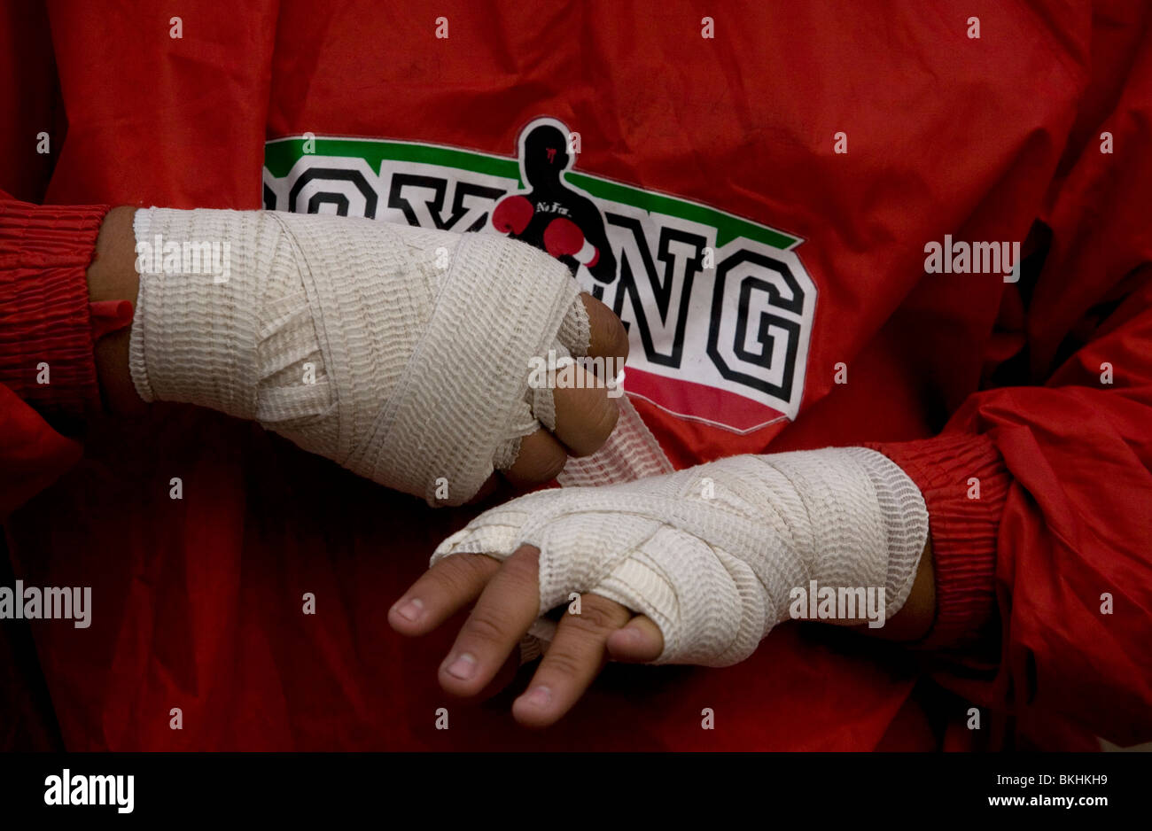 A boxer puts bandage in his hands before using his boxing gloves during ...