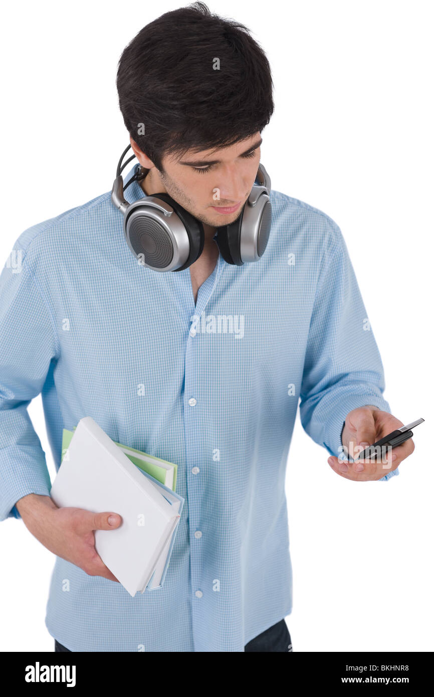 Male student sending text message holding books on white background ...