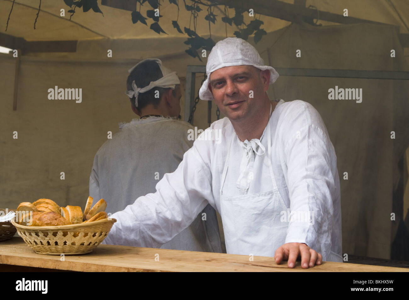 Baker at a bakery with bread on the counter Stock Photo - Alamy
