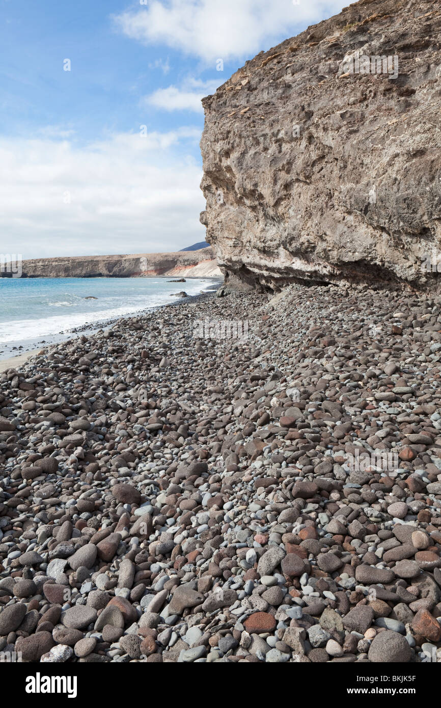A beach of volcanic rock pebbles near the harbour at Morro del Jable ...