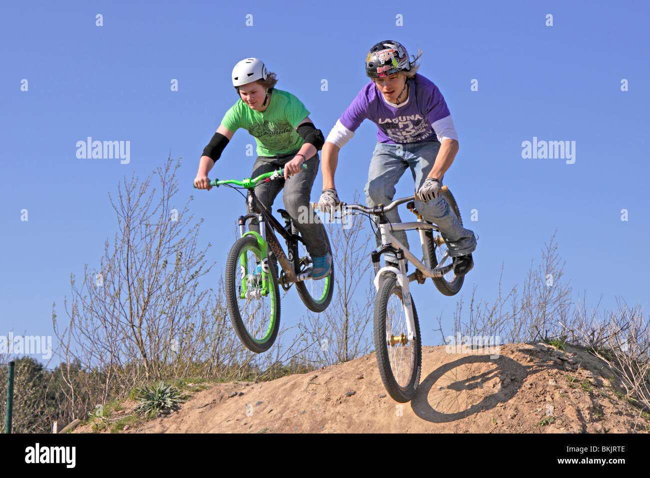 two teenage boy jumping together with their bikes Stock Photo - Alamy
