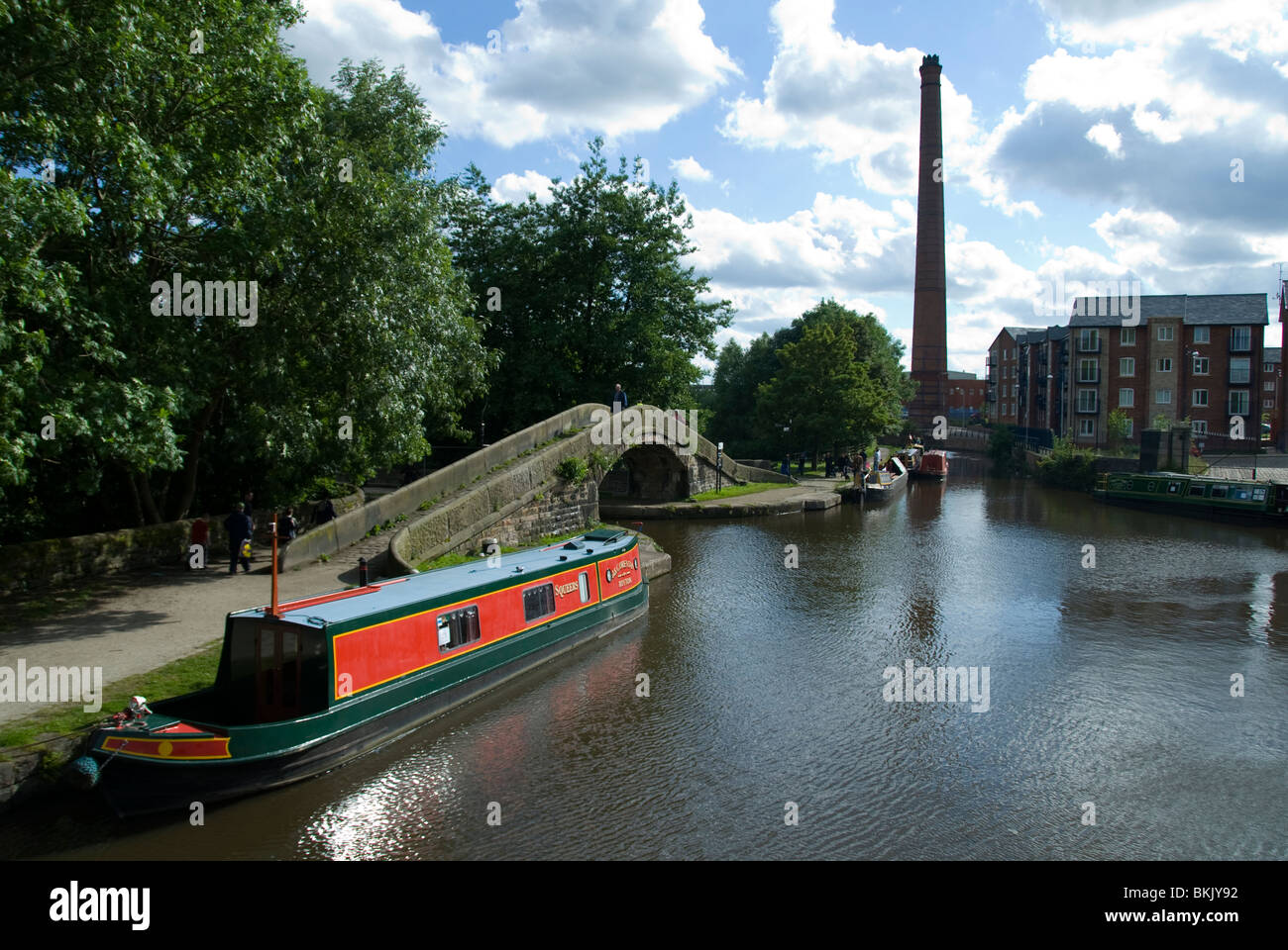 Narrowboat, footbridge and mill chimney at Portland Basin, Ashton under ...