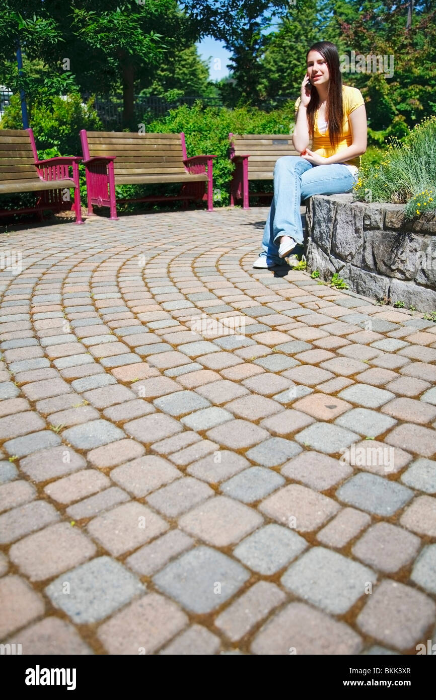 A Teenage Girl Sitting Outside Talking On Her Cellphone Stock Photo - Alamy