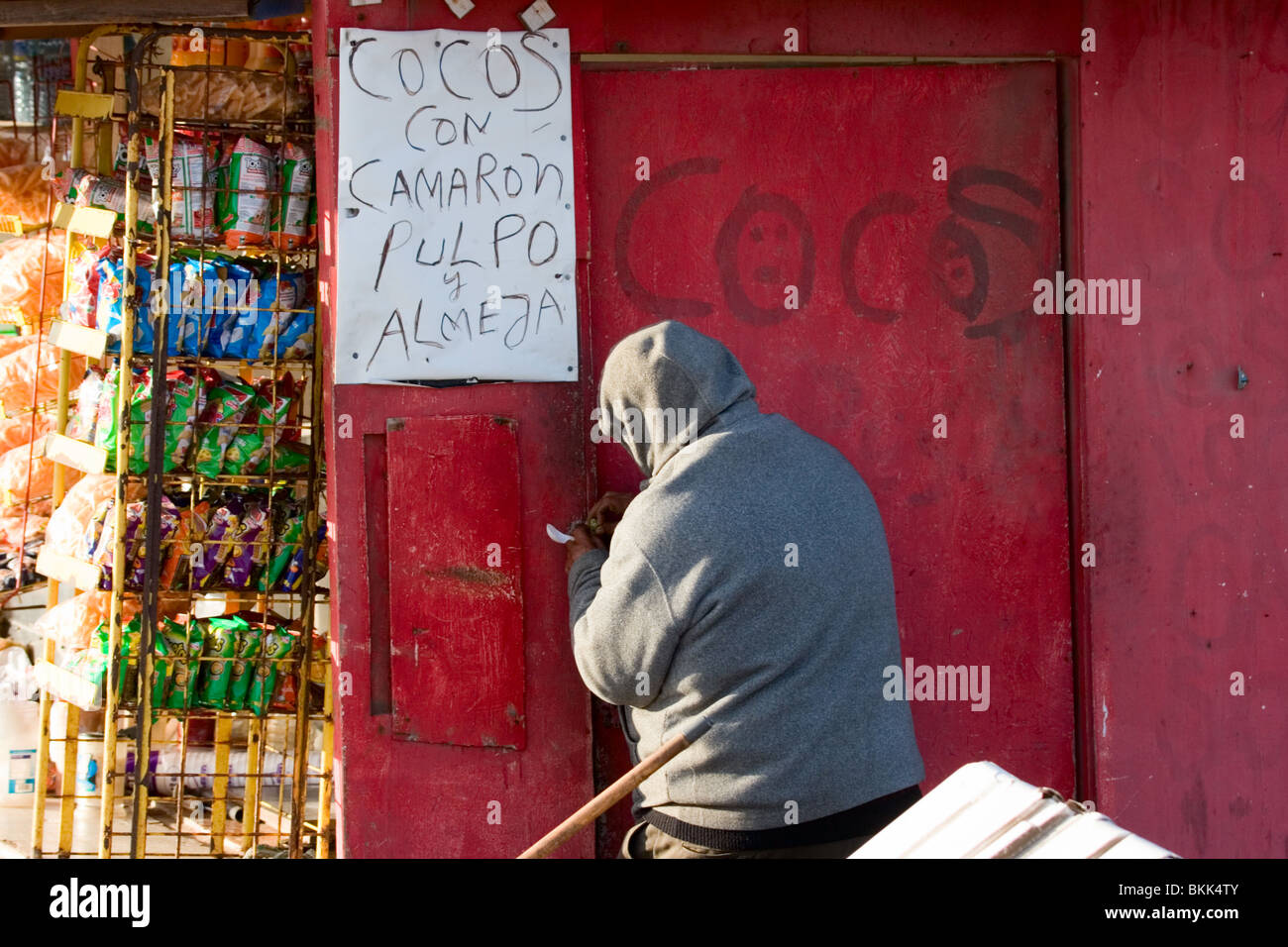 A street vendor wakes up early to to open up shop at a roadside stand ...