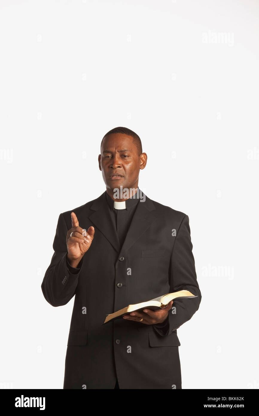 A Man Wearing A Clerical Collar And Preaching From The Bible Stock ...