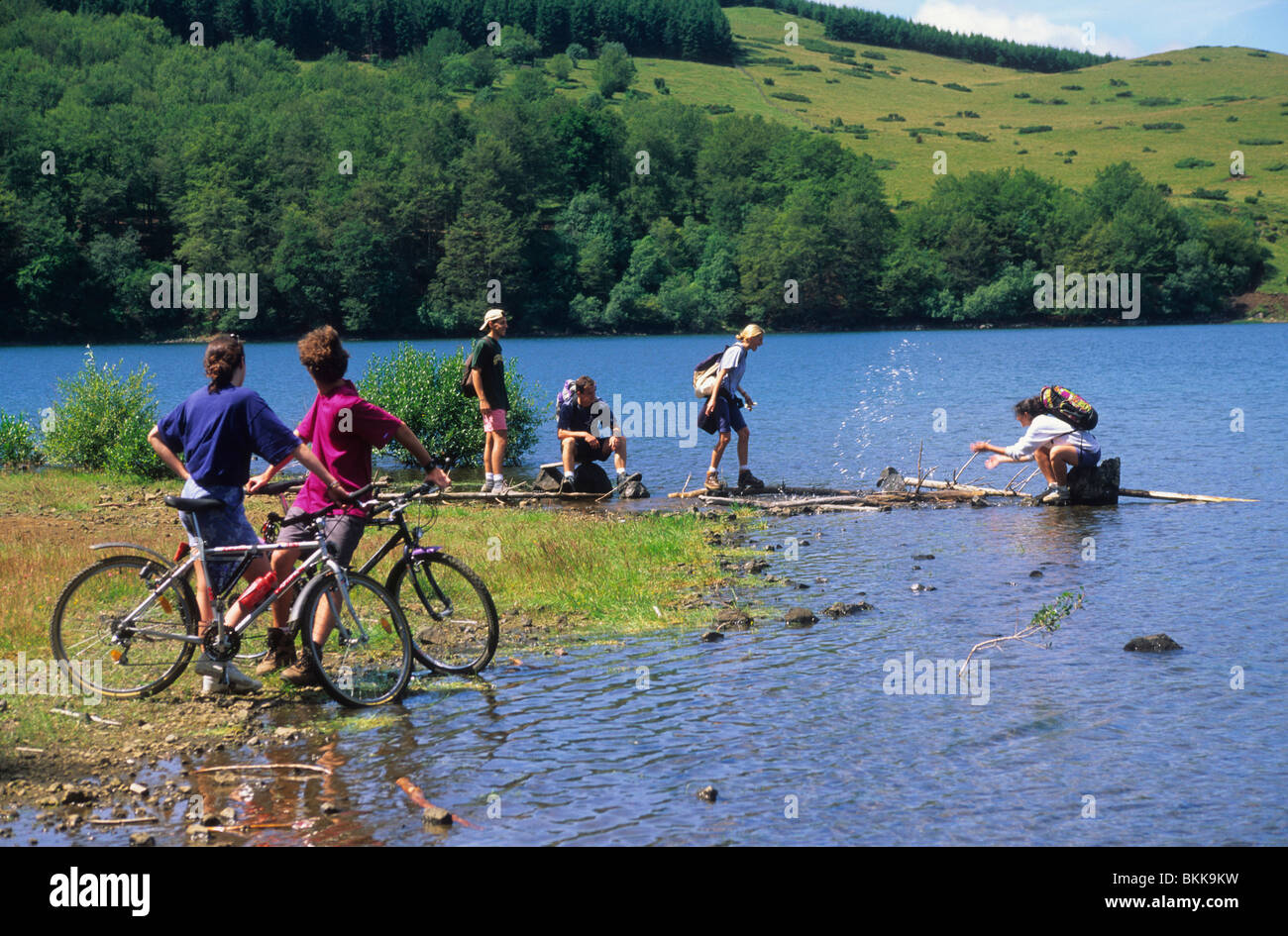 Group of boys and girls playing at the edge of a lake Stock Photo - Alamy