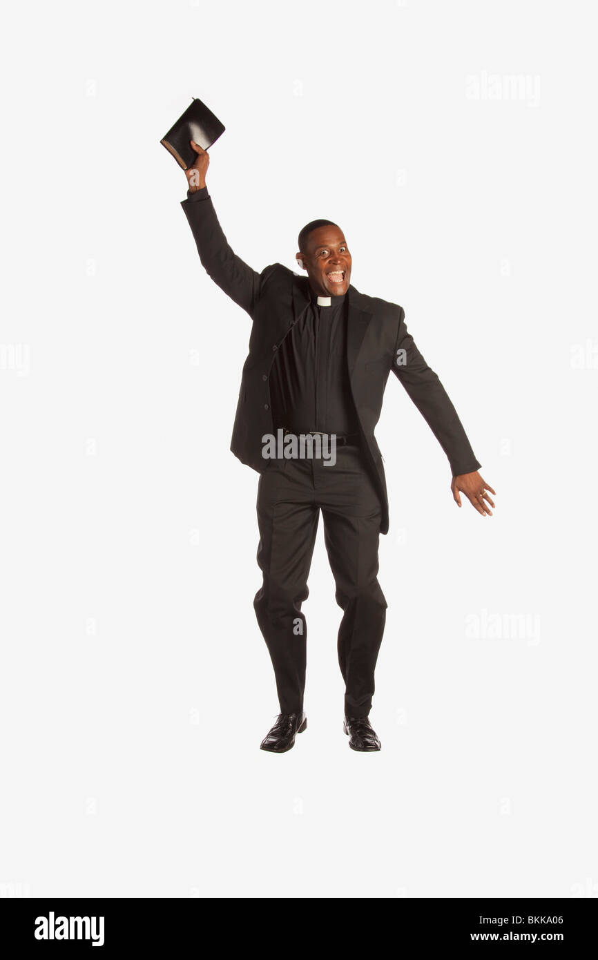 A Man Wearing A Clerical Collar Holding His Bible And Jumping In The ...