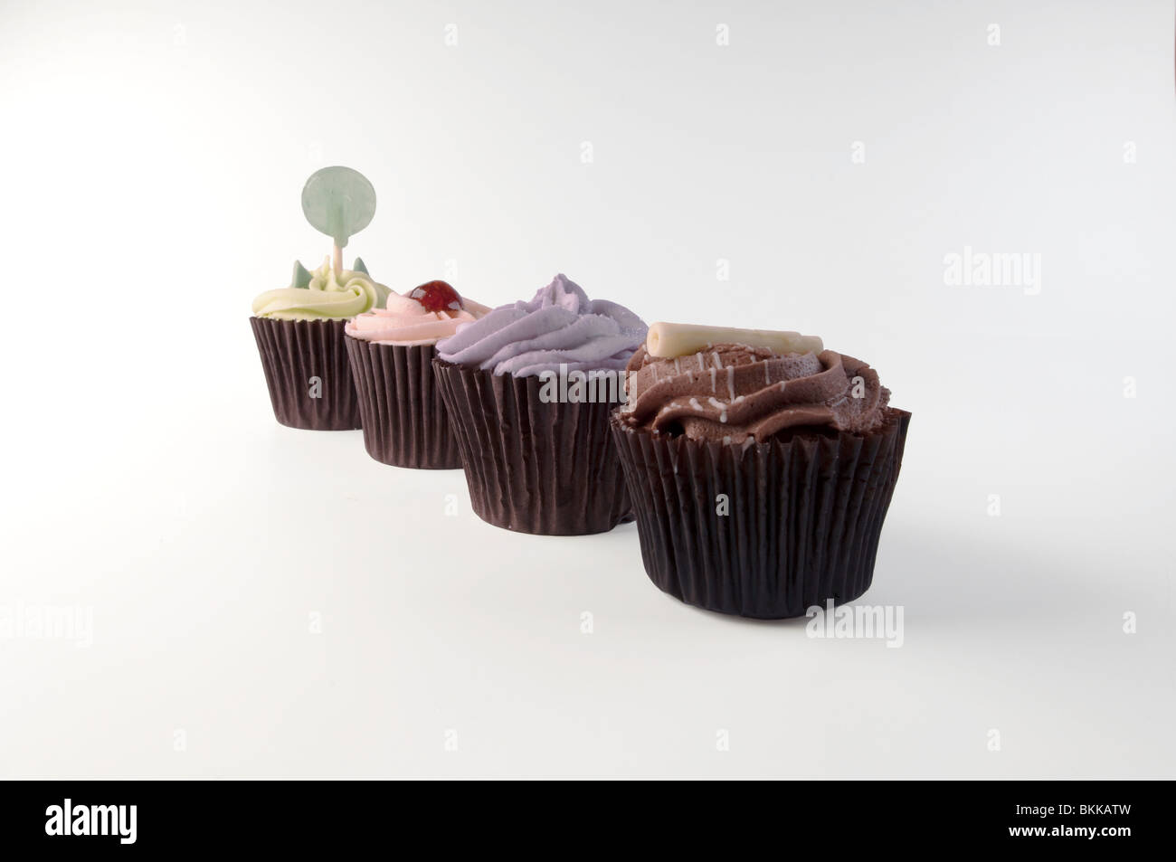 Line of cup cakes against white background Stock Photo - Alamy