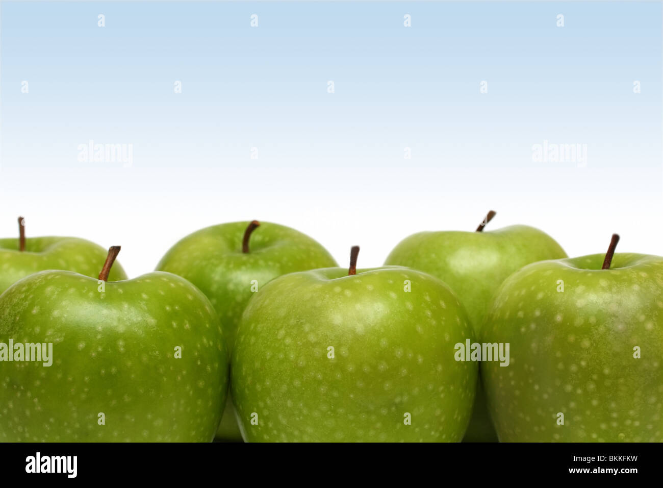 few green apples on gradient blue background Stock Photo - Alamy
