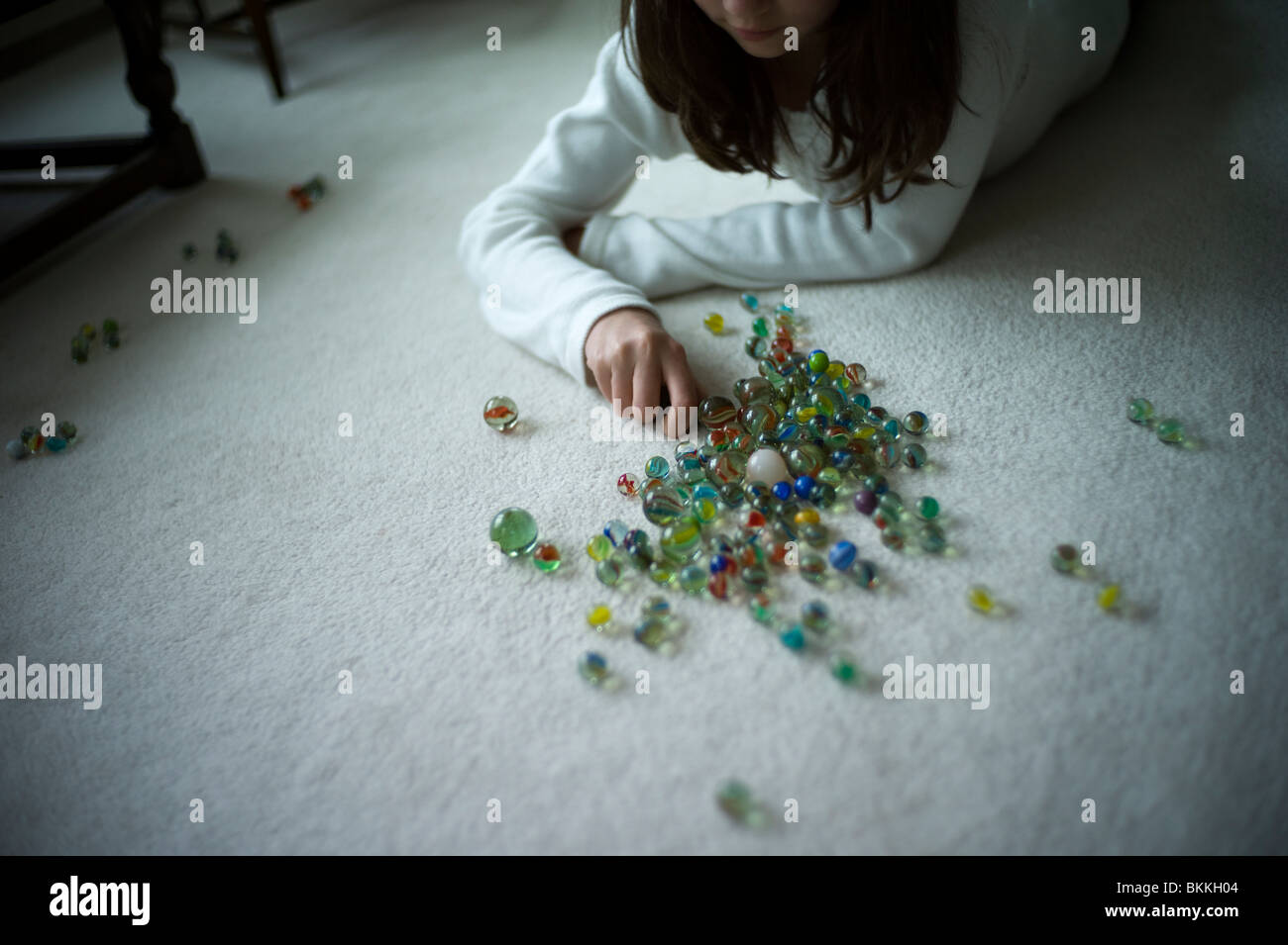 Wide angle shot of young girl playing with marbles Stock Photo - Alamy