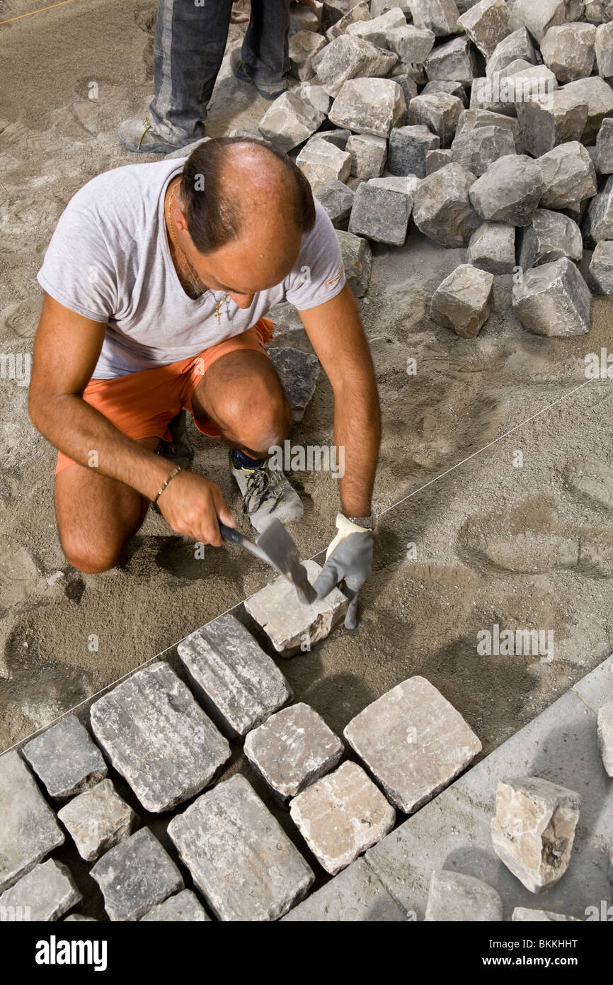 worker positioning cobblestone Stock Photo - Alamy