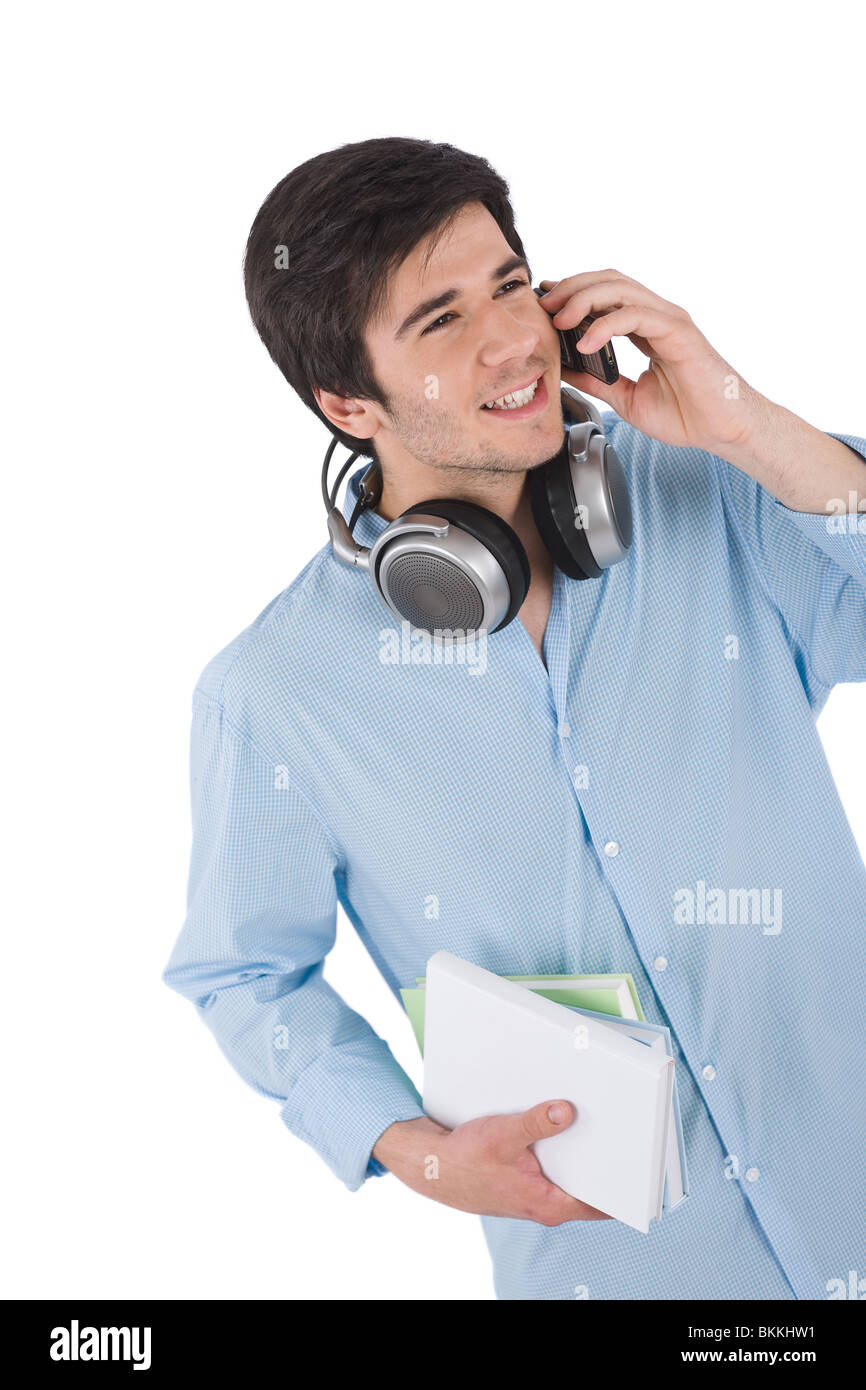 Male student calling with mobile phone holding books on white ...