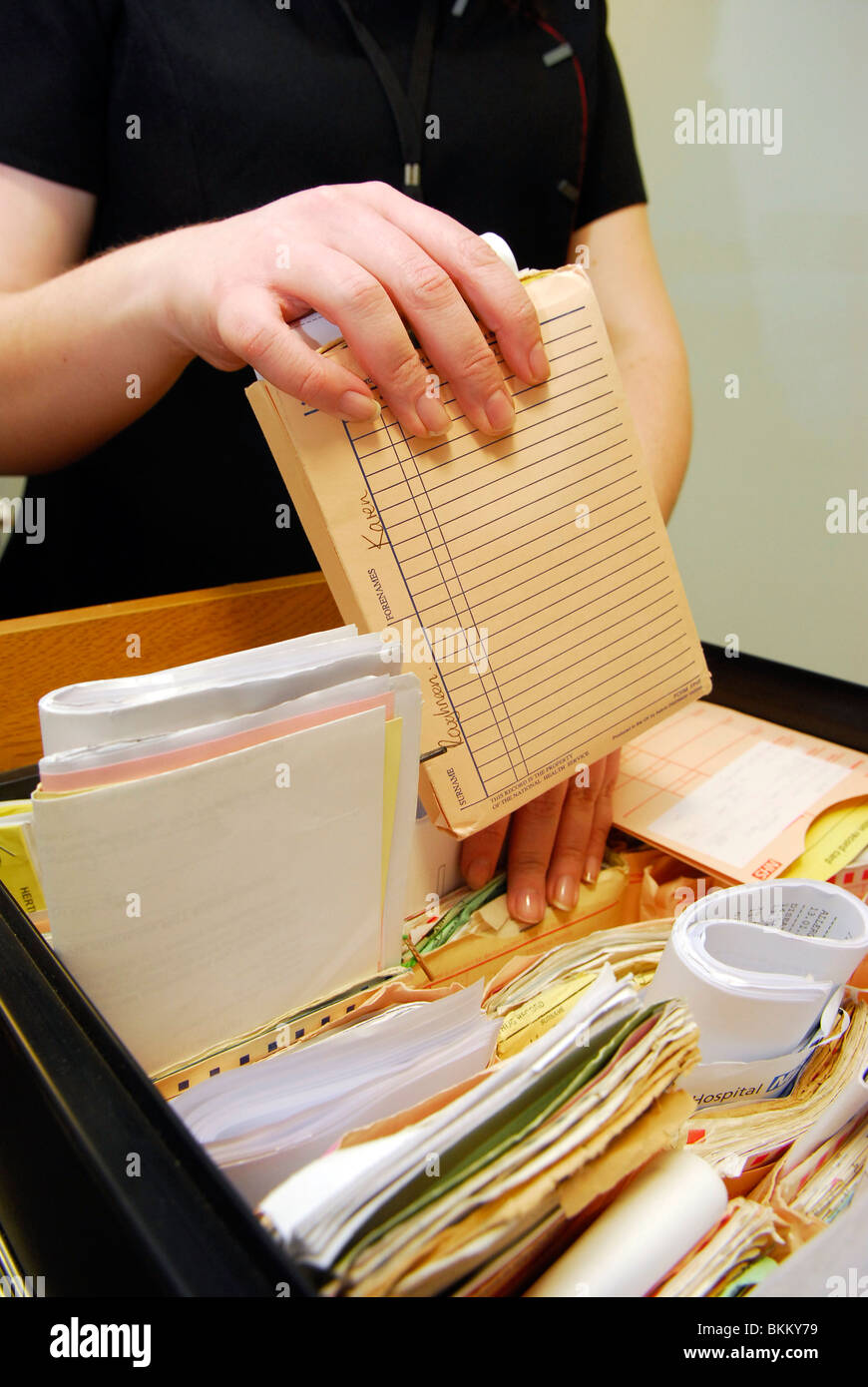 Healthcare receptionist filing patient notes, Barnsley, Yorkshire, UK ...