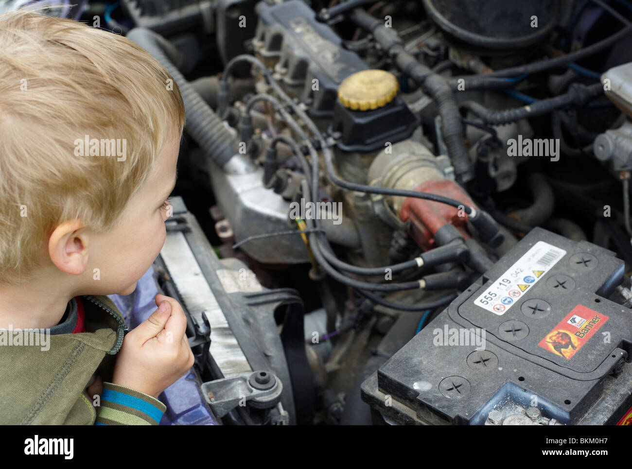Child blond boy checking the condition of car engine Stock Photo - Alamy