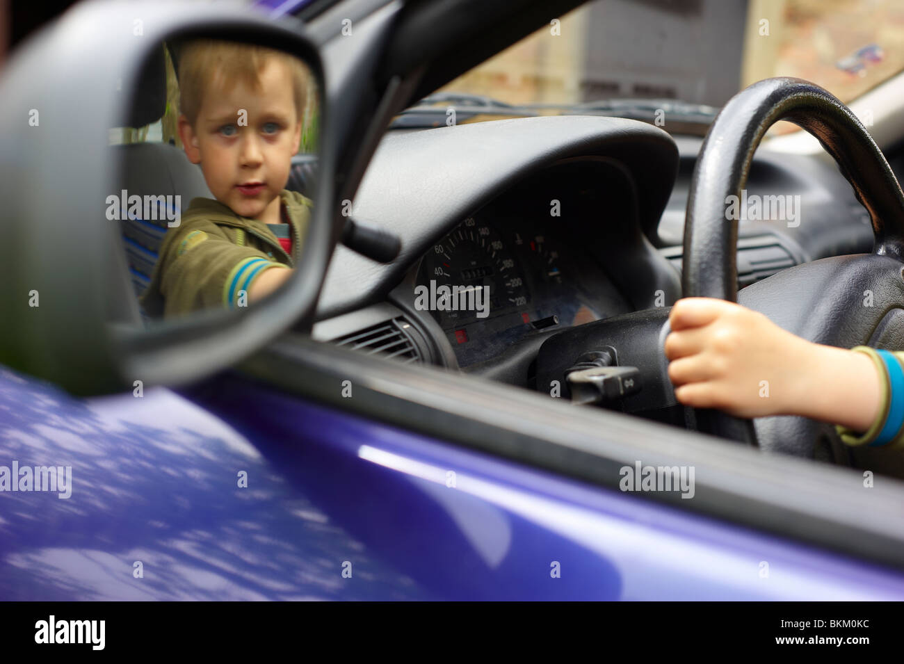 Child blond boy driving - playing real car Stock Photo - Alamy