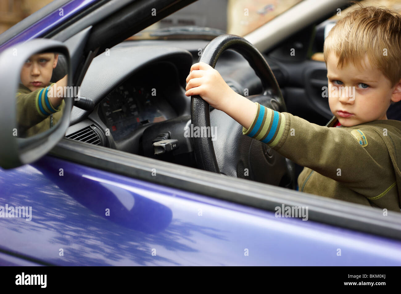 Child blond boy driving - playing real car Stock Photo - Alamy