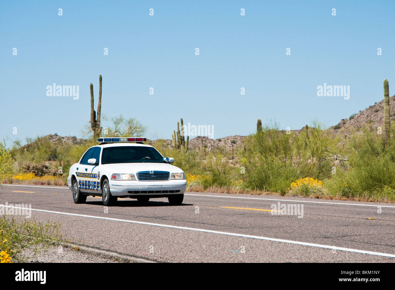 a sheriff's patrol car travels through the desert Stock Photo - Alamy