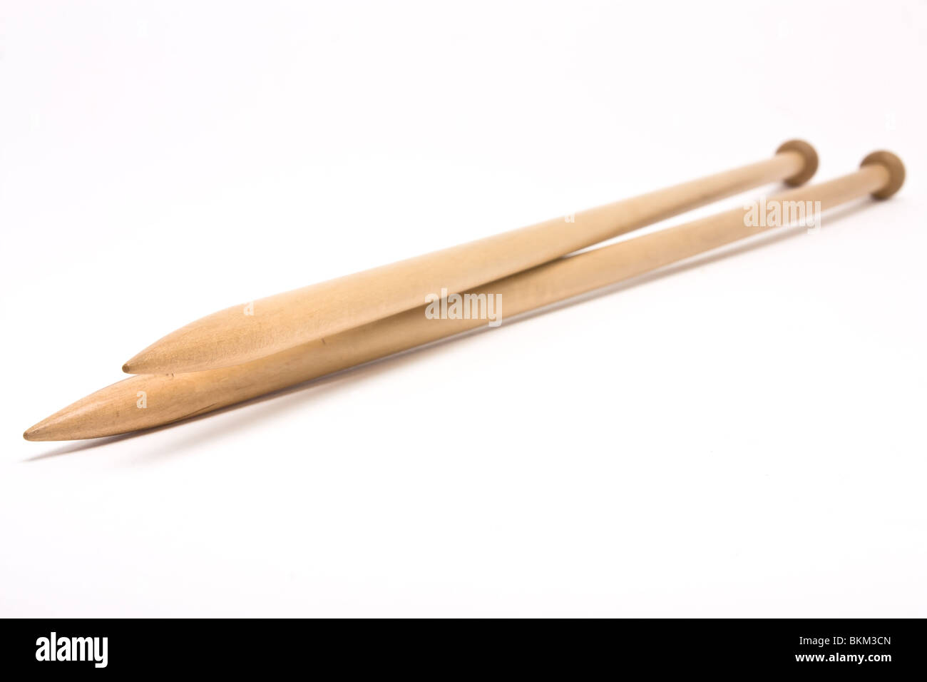 A pair of large wooden knitting needles from low perspective isolated ...
