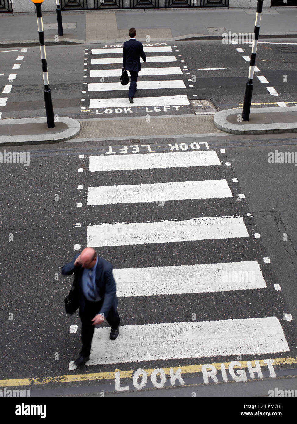 Commuters crossing a zebra pelican crossing in London, UK, with 'Look ...