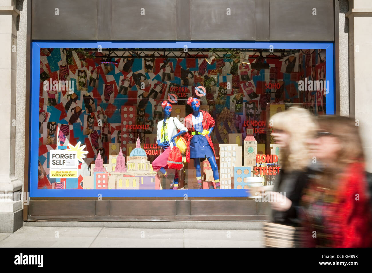 Shoppers walking past a shop window in Selfridges department store ...