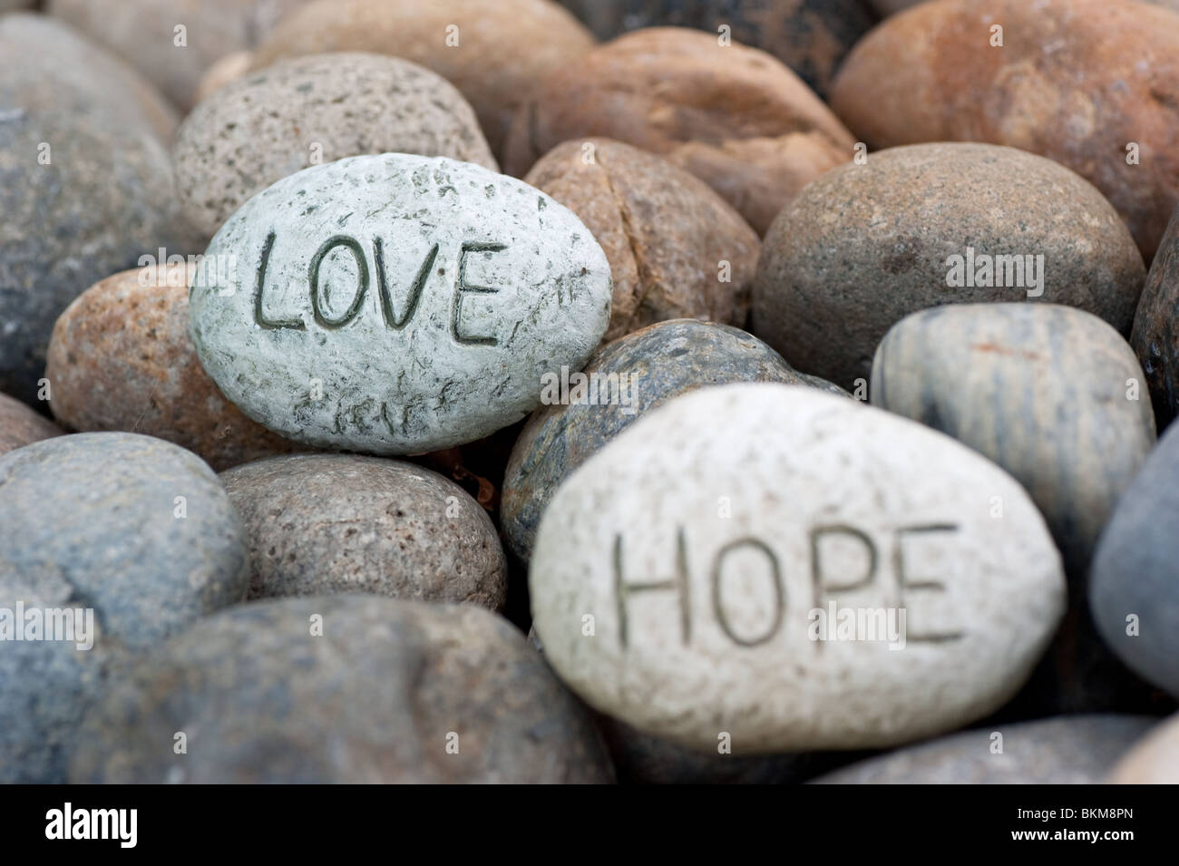 love and hope carved into round rocks Stock Photo - Alamy