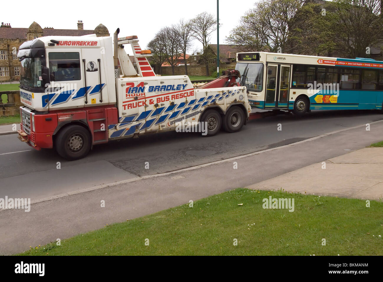 Tow truck pulling away with a broken down bus Stock Photo - Alamy