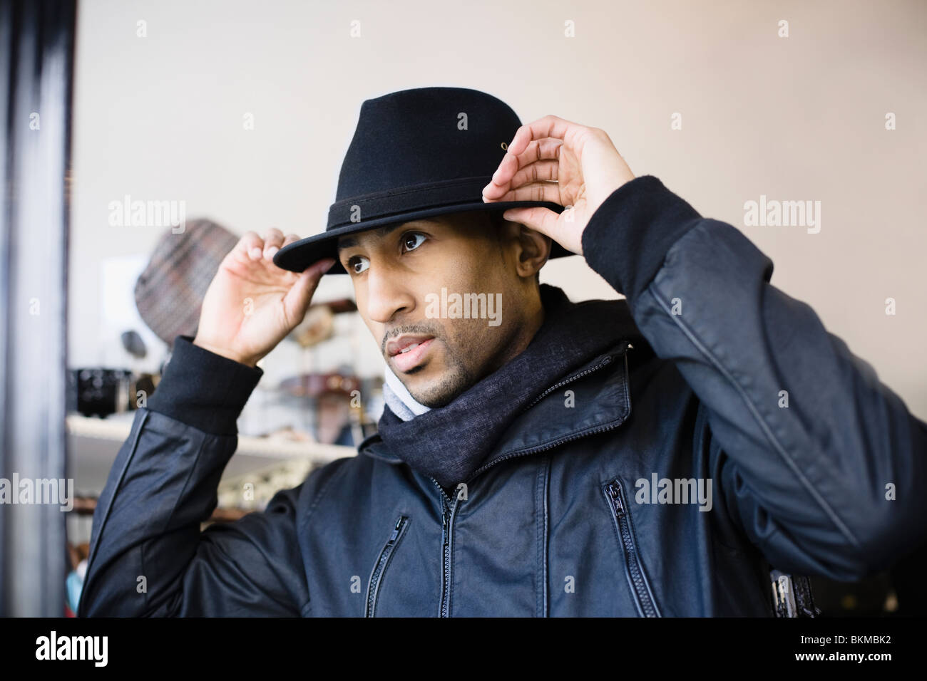African American man adjusting fedora Stock Photo - Alamy