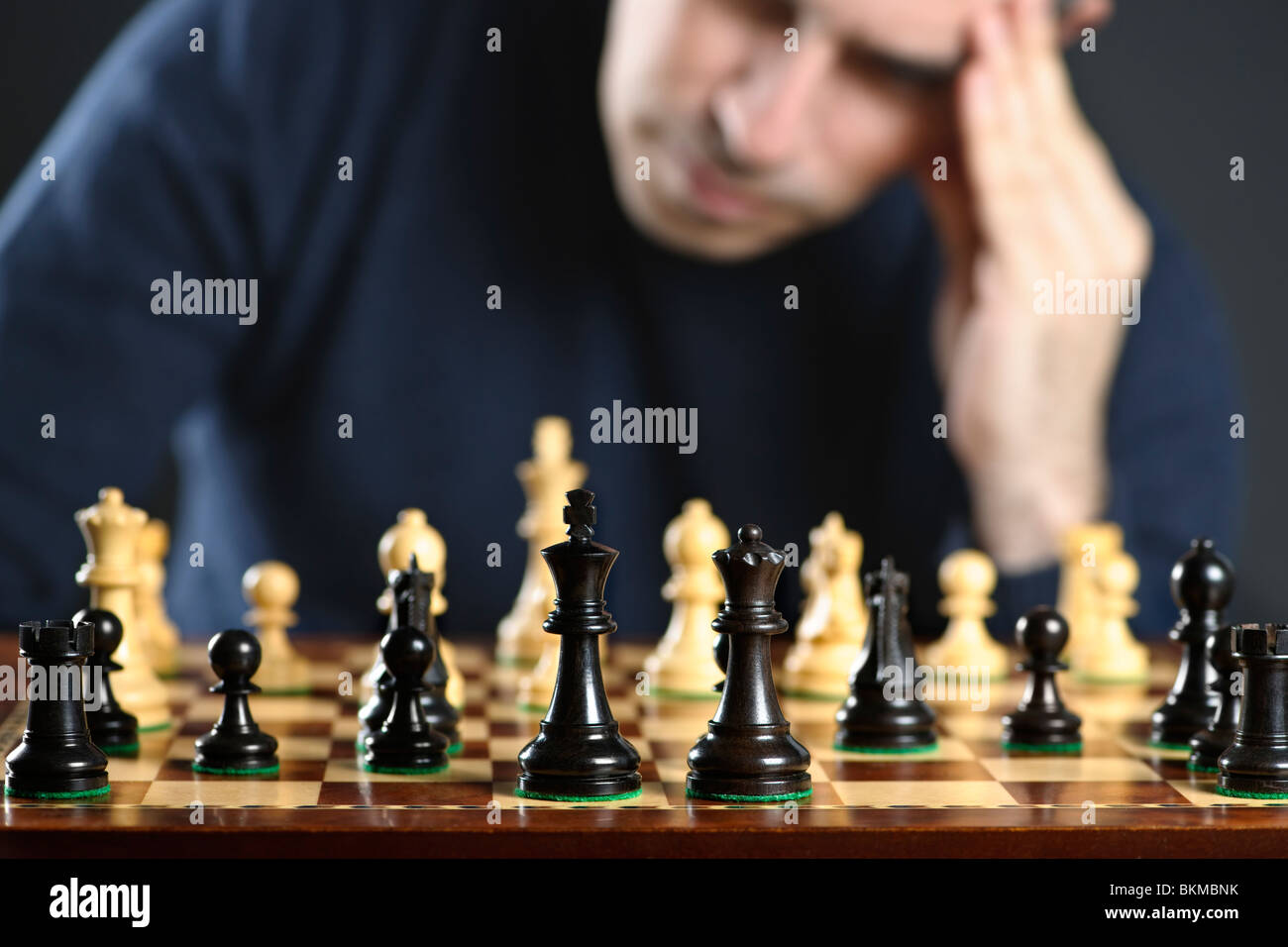 Chessboard with man thinking about chess strategy Stock Photo - Alamy