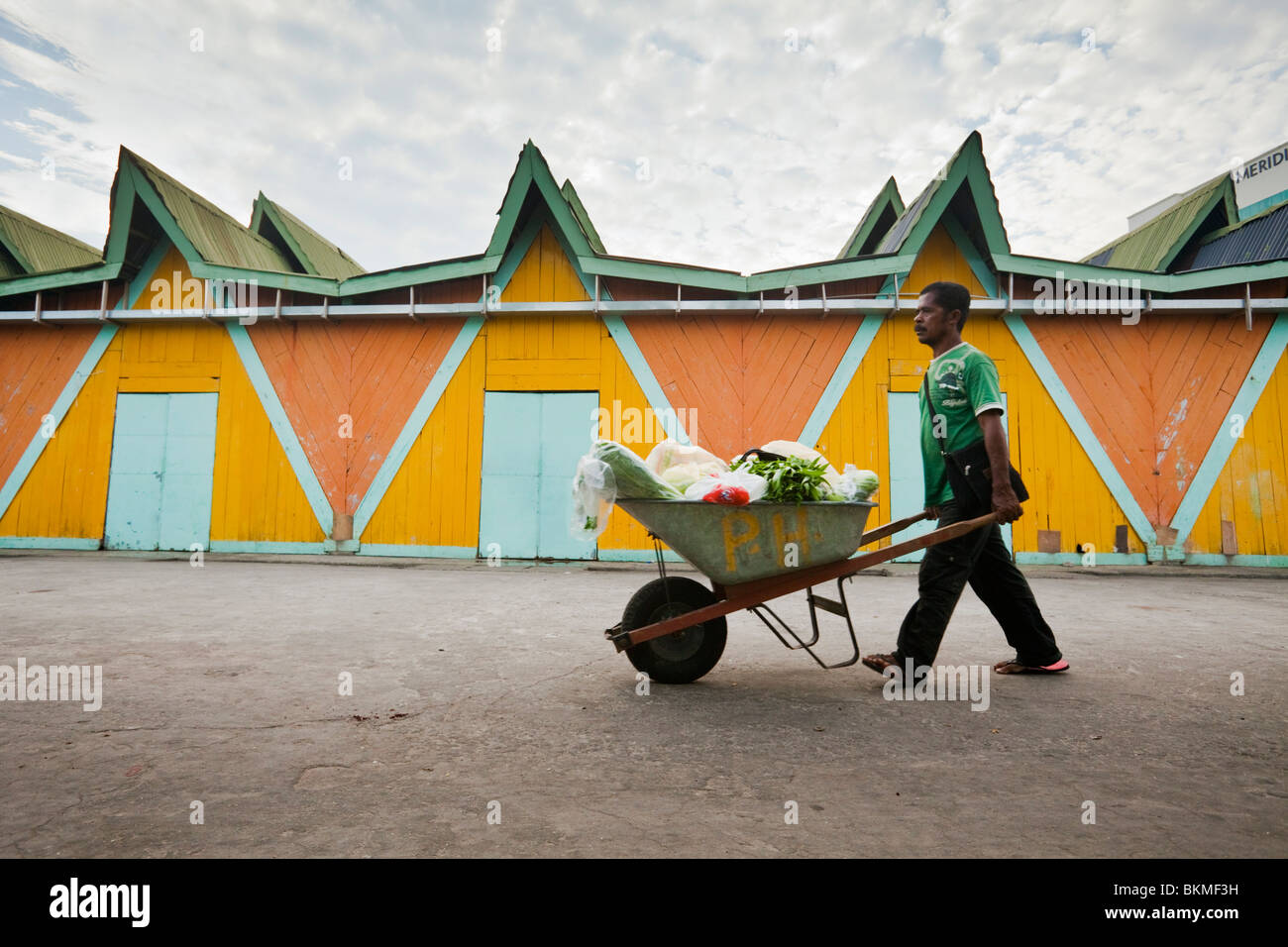 Man pushing wheelbarrow full of produce, in front of the Filipino ...