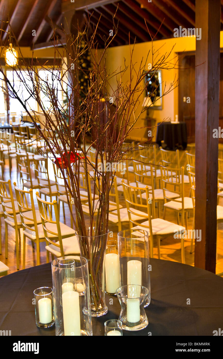 An empty wedding reception venue, with a branches in a vase and candles ...