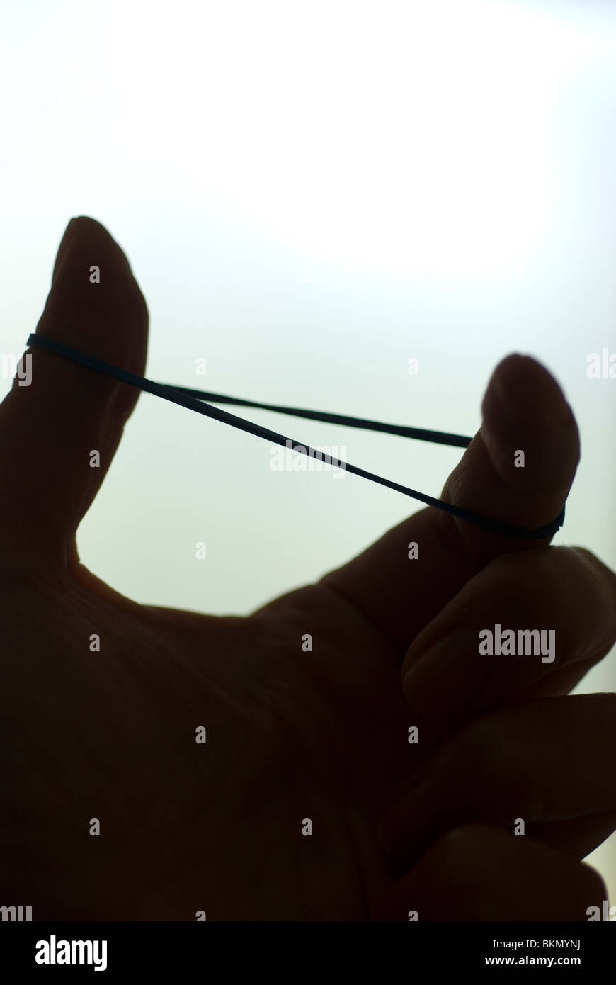 Woman´s hand holding an elastic rubber Stock Photo - Alamy