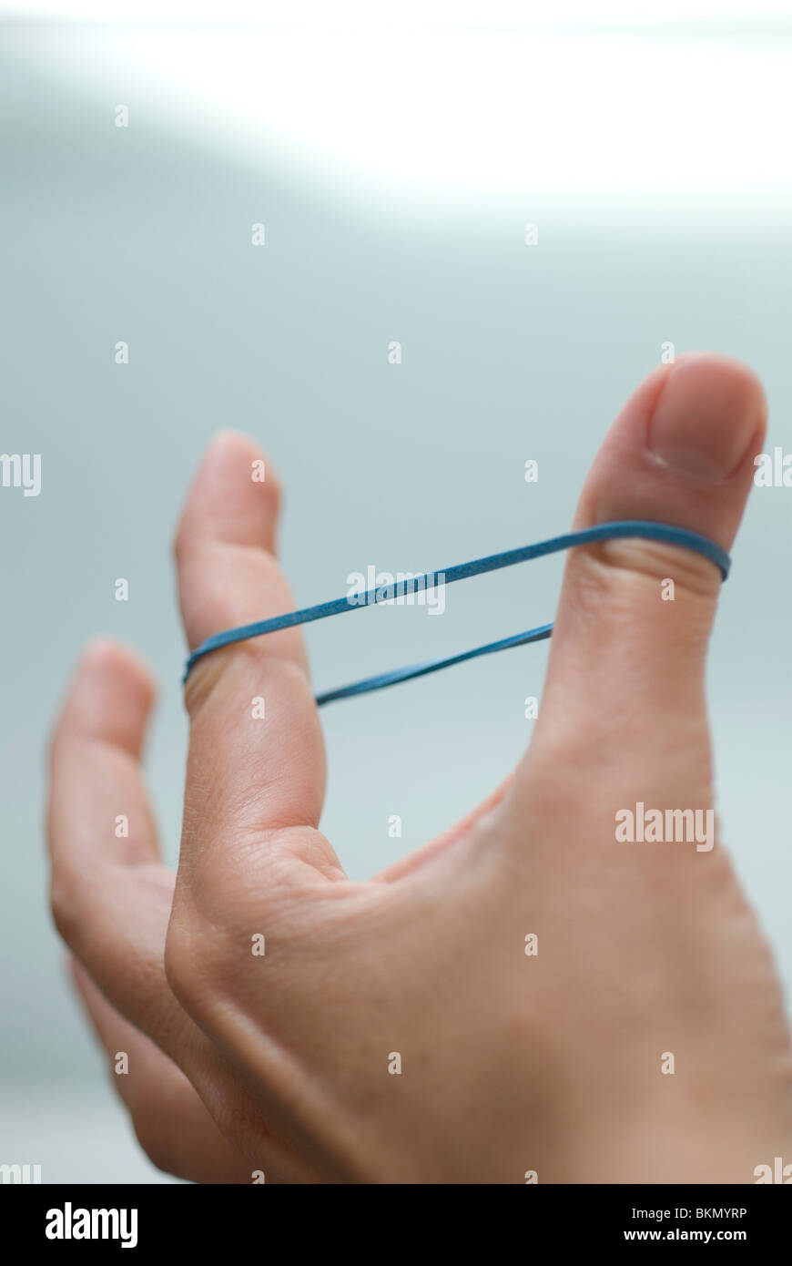 Woman´s hand holding an elastic rubber Stock Photo - Alamy