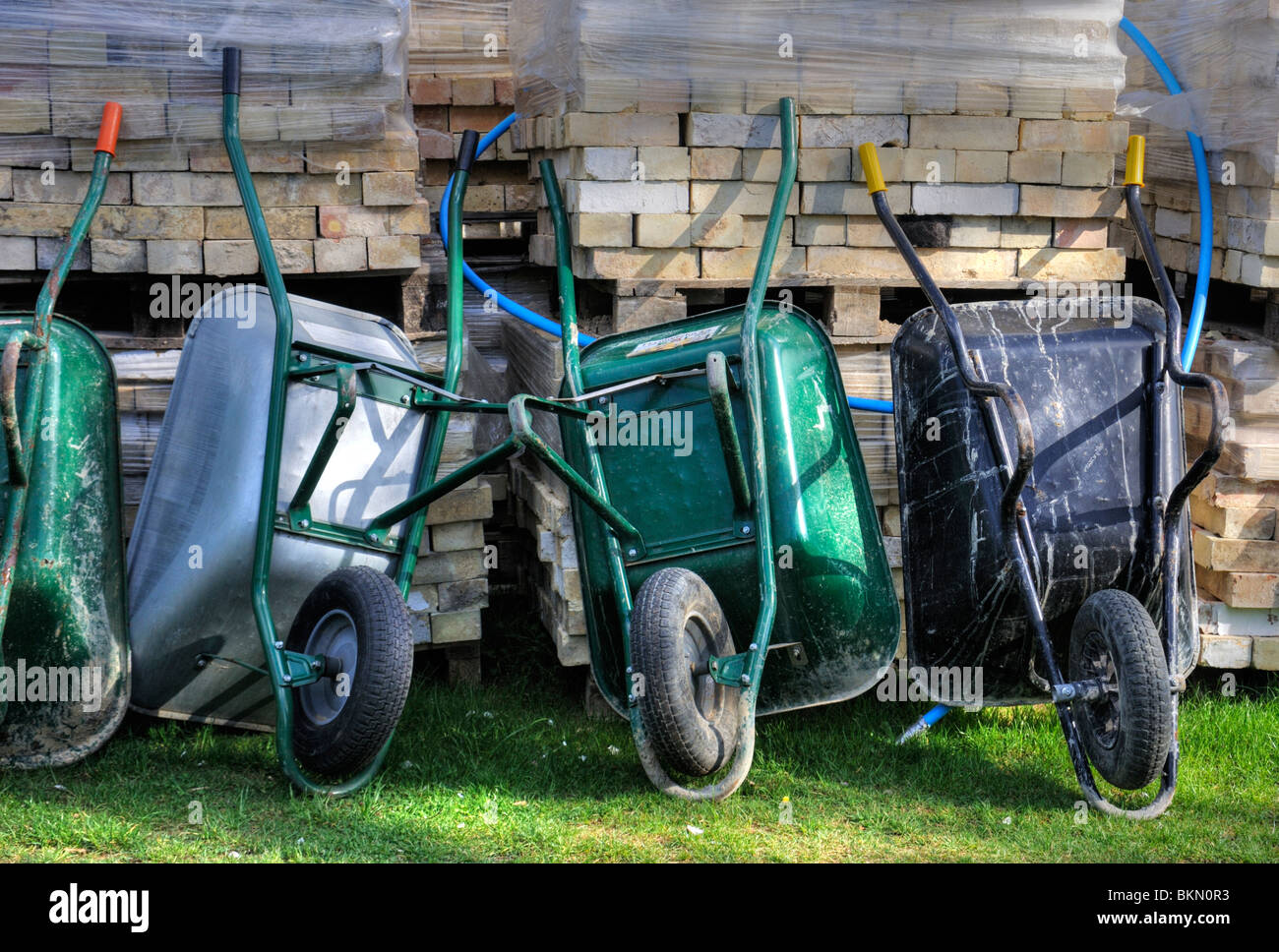 builder's wheel barrows neatly stacked against pile of bricks Stock ...