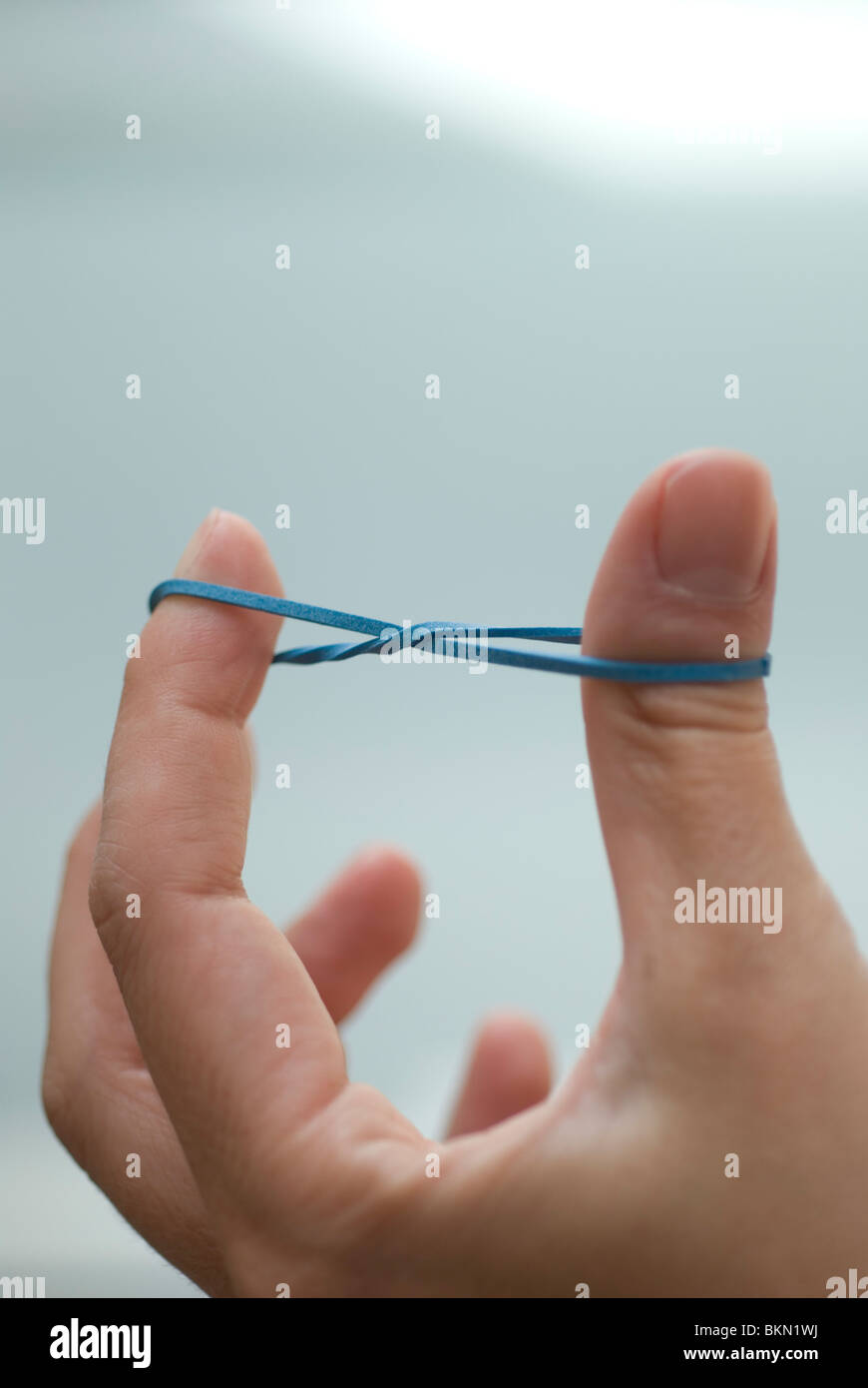 Woman´s hand holding an elastic rubber Stock Photo - Alamy