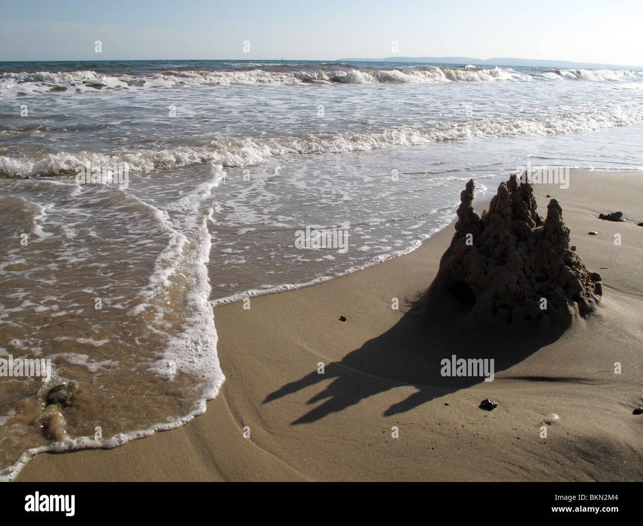 Sand castle washing away Stock Photo - Alamy