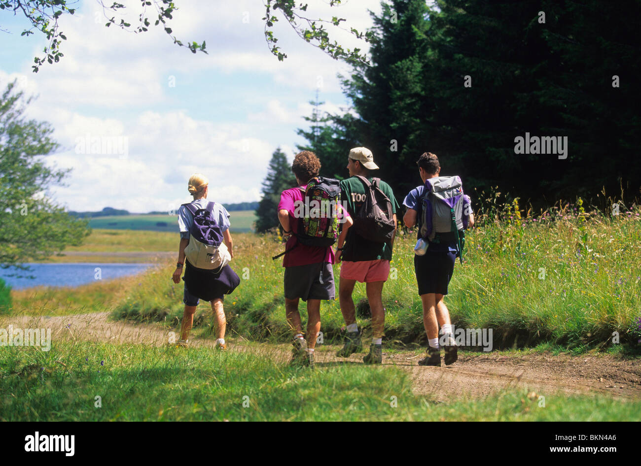 Group of young people backpacking near a lake in Auvergne, France Stock ...