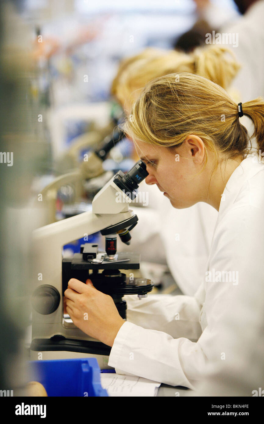 Female university student in a science lab performing an experiment ...