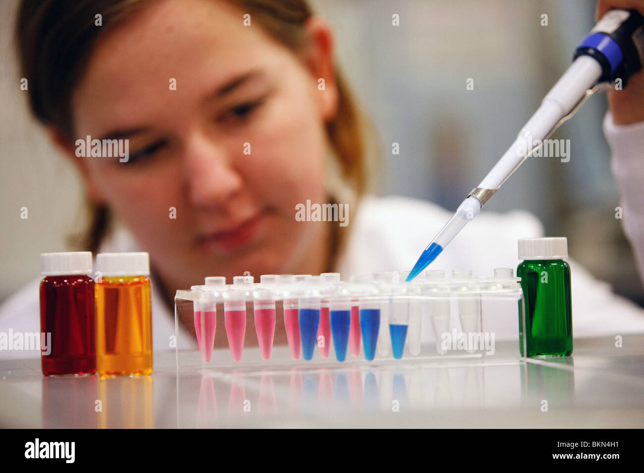 Female university student in a science lab performing an experiment ...