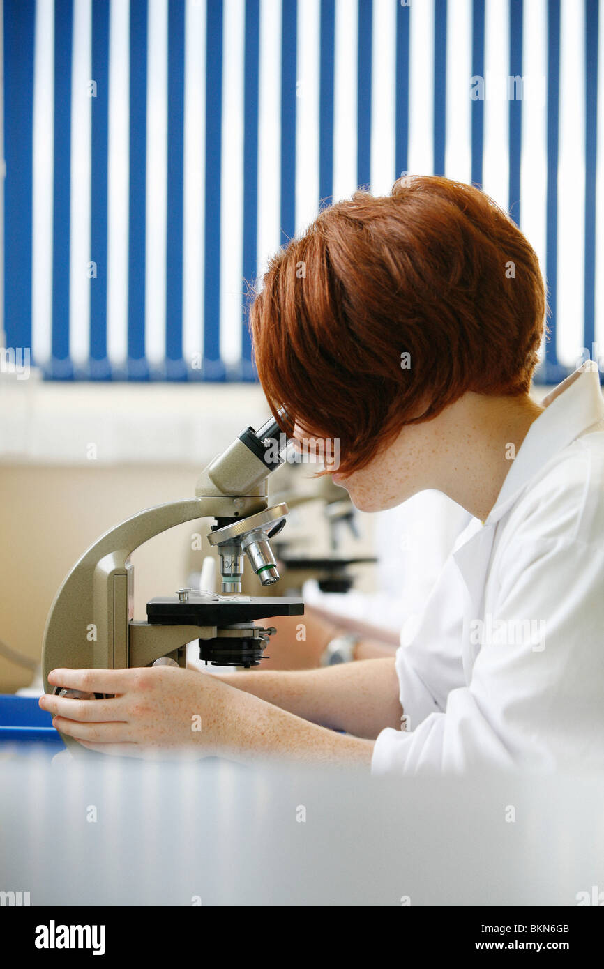 Female university student in a science lab performing an experiment ...